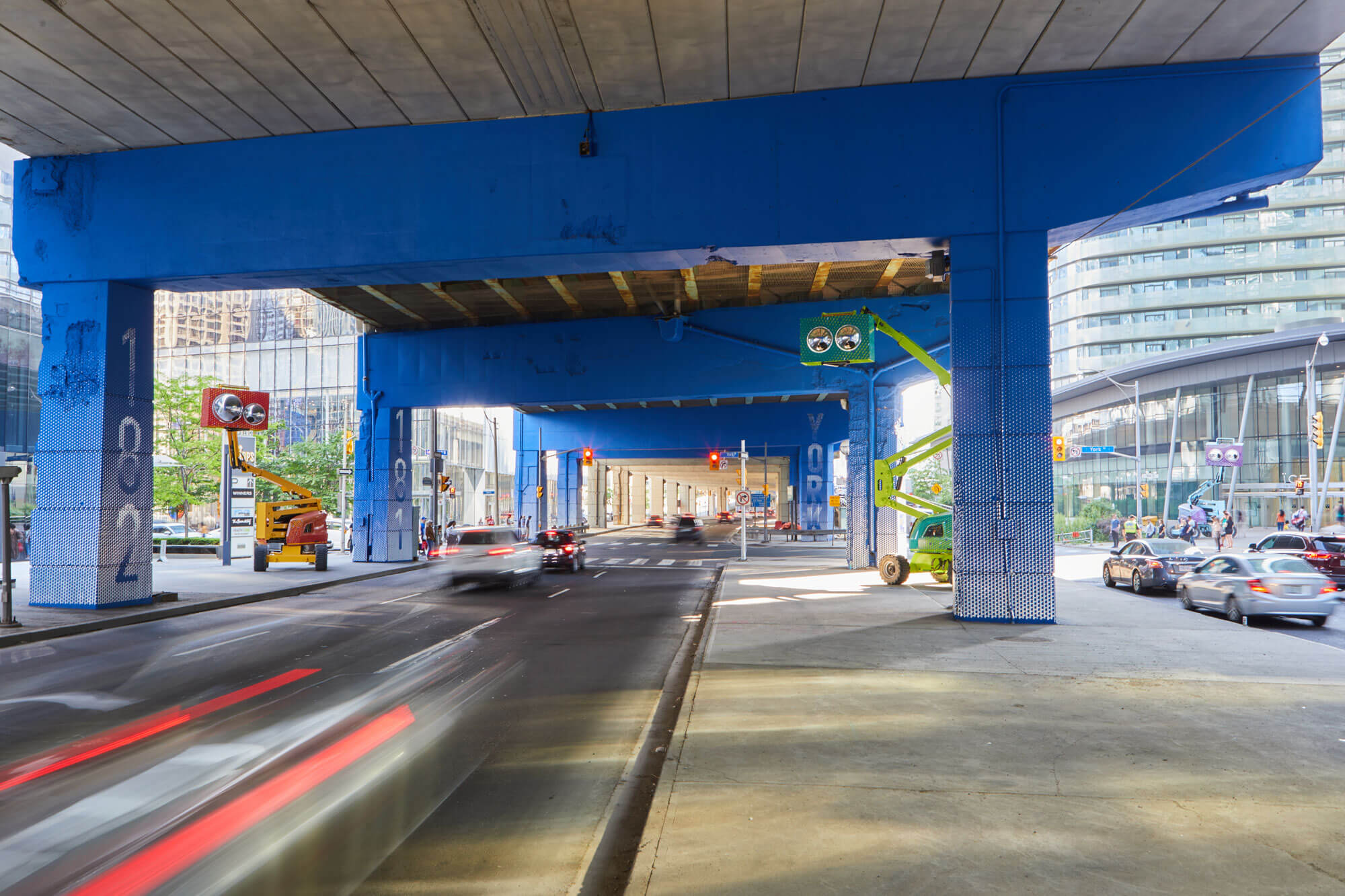 A public arts display along Toronto’s Bentway, dresses up boom lifts